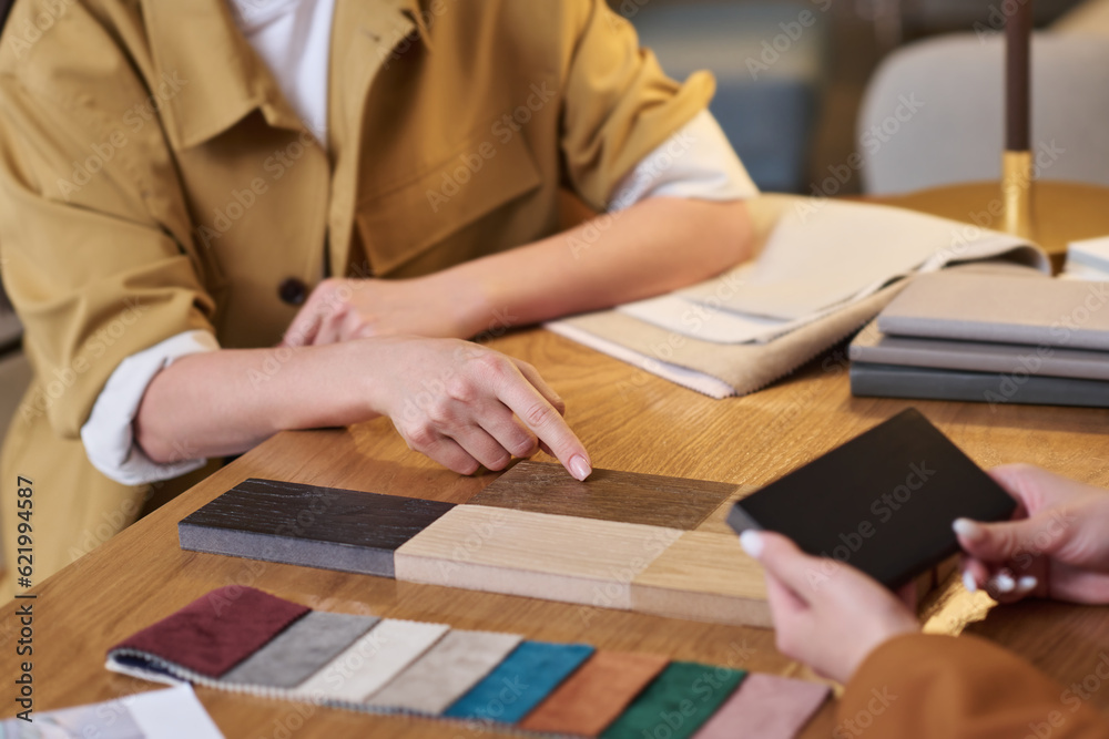 Hand of young female client pointing at sample of brown color while ...