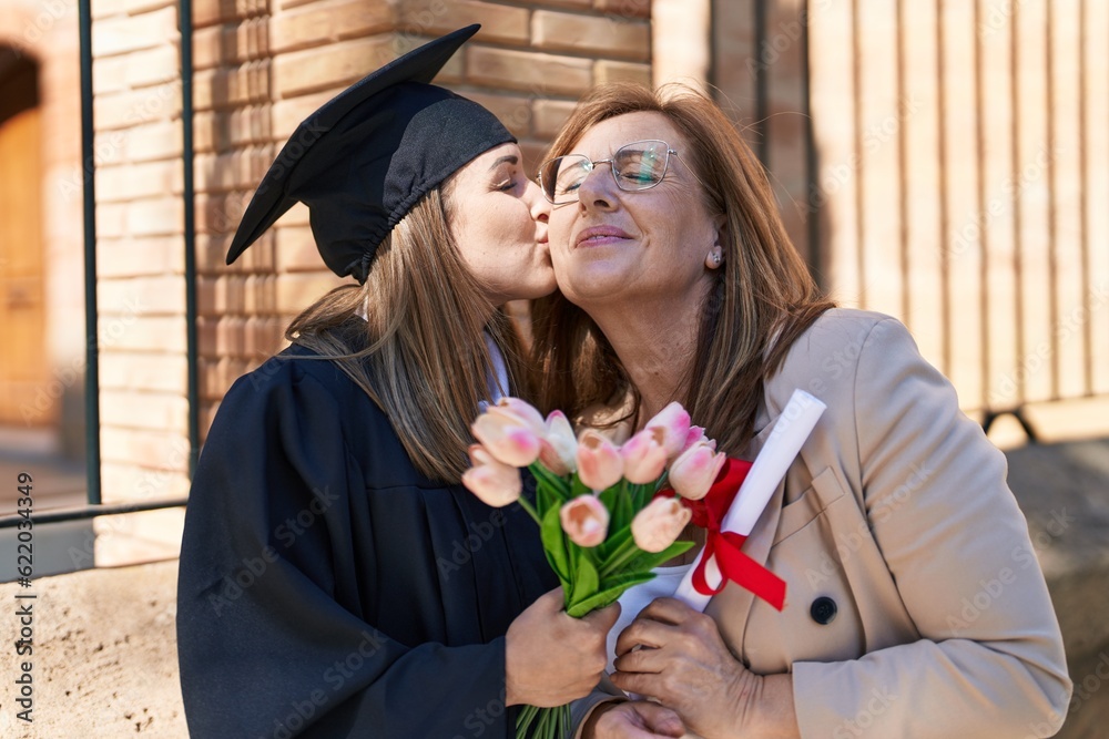 Mother and daughter hugging each other celebrating graduation holding ...