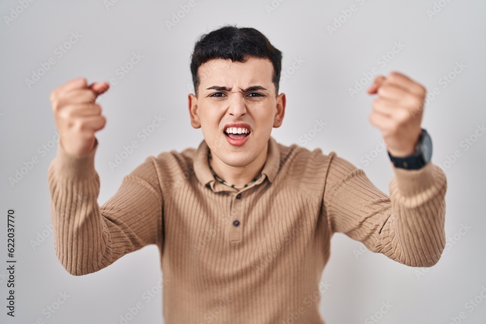 Non binary person standing over isolated background angry and mad ...