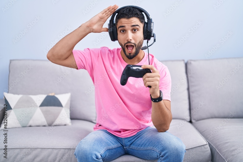 Foto de Hispanic young man playing video game holding controller ...