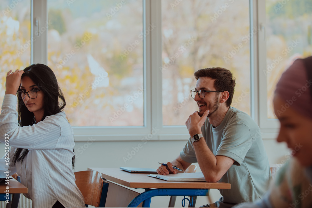 A group of diverse students engages in lively discussion as they ...