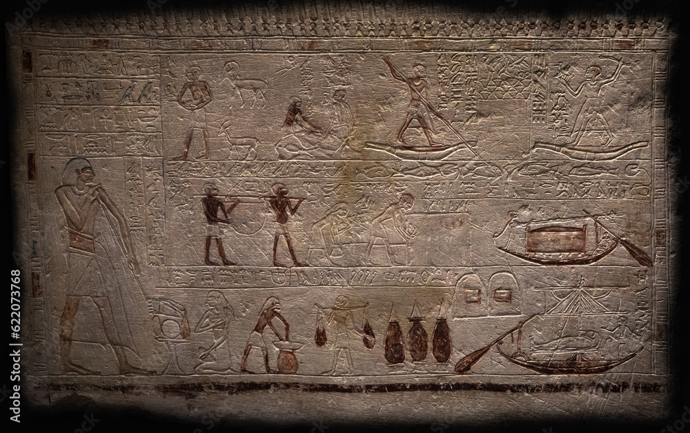 An Egyptian stone tablet isolated on a black background, on which ...