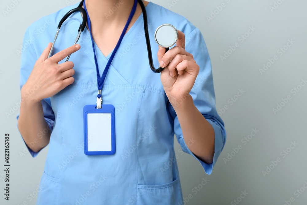 Female doctor with stethoscope and badge on grey background Stock Photo ...