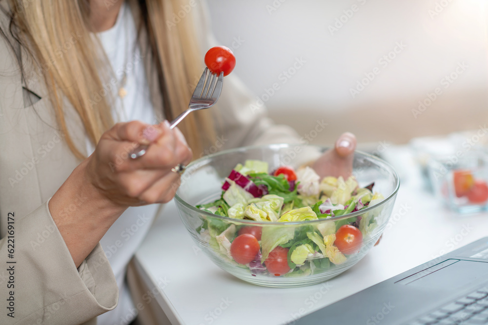 Foto de Healthy eating at work. Woman indulges in a delightful fresh ...