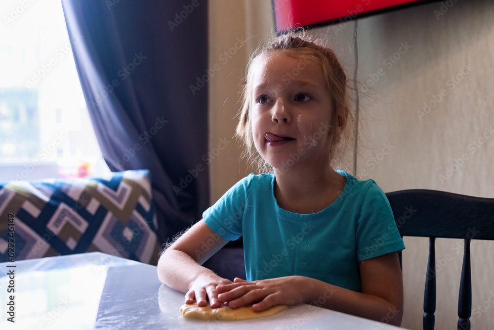 Funny little girl 5 year old at kitchen table cooking cookies from ...