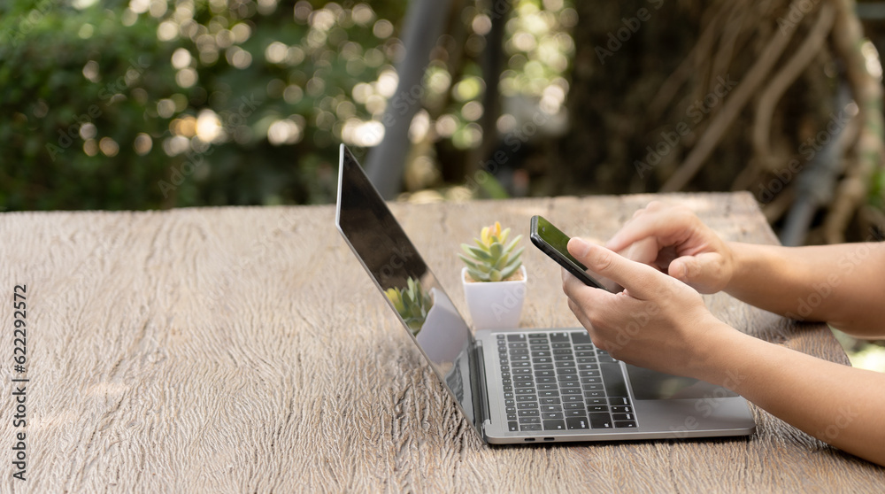 person's hand deftly manipulated both mobile phone and notebook ...