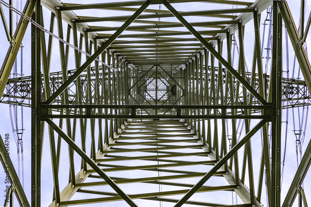 Zoom view up in high voltage pylon with patterns and steel girders ...