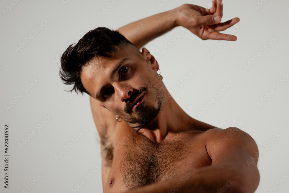 A man poses with his arms stretching and his head tilted, expressing a ...