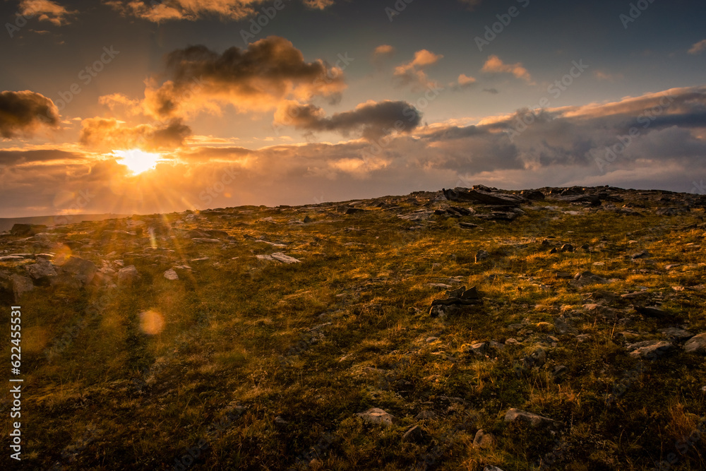 Midnight sun rising over Knivskjellodden, a trail in the tundra towards ...