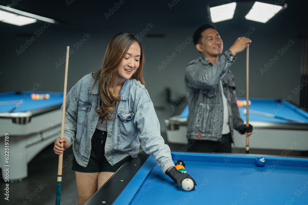 female pool player set up the billiard balls while the male player ...
