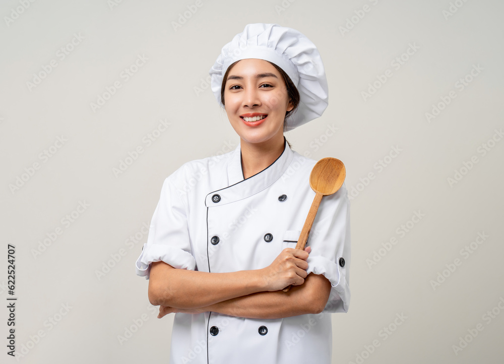 Young beautiful asian woman chef in uniform holding ladle utensils ...