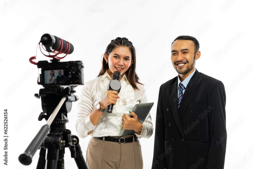 a female journalist in white blouse talking to the camera using a black ...