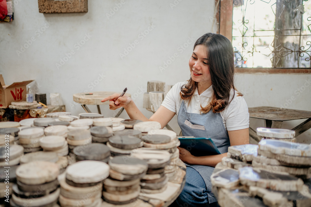 beautiful Asian woman stone craft entrepreneur pointing to a pile of ...