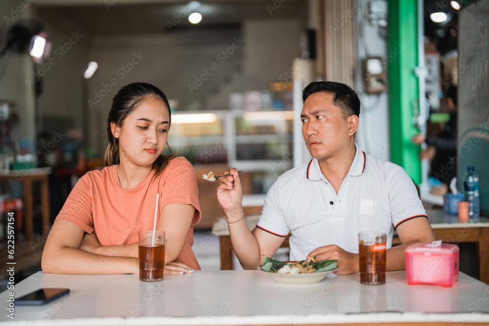 beautiful woman pouts when refused to be fed by boyfriend when eating ...
