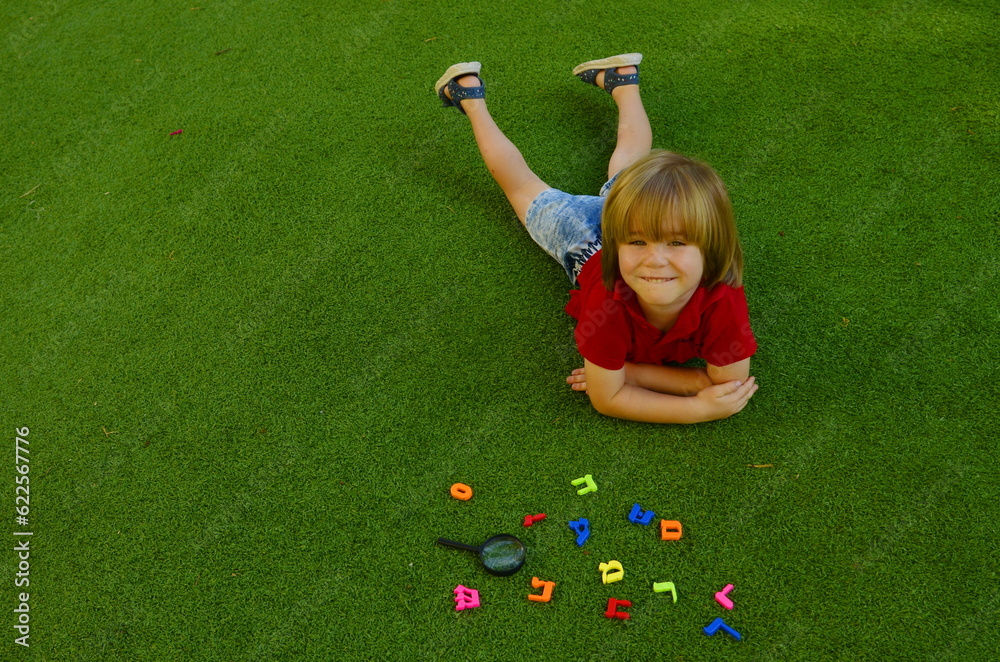Hebrew alphabet. The boy is learning Hebrew. Multi-colored letters on ...