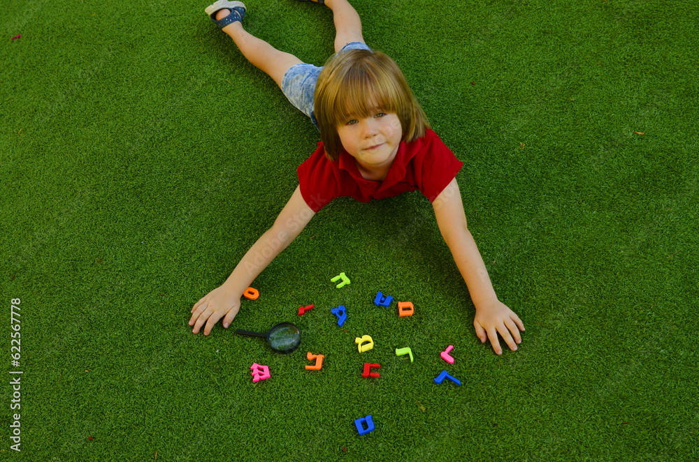 Hebrew alphabet. The boy is learning Hebrew. Multi-colored letters on ...