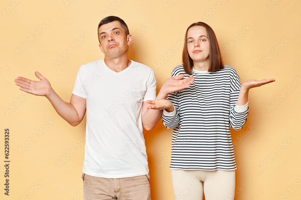 Uncertain puzzled young couple wife and husband wearing casual attires ...