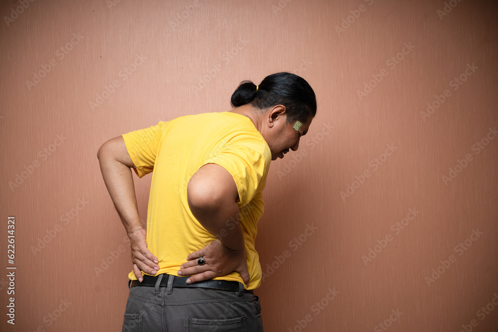 old asian man suffering from backpain with clenching his back gesture ...