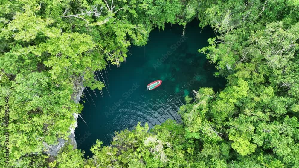 Ocean water fills a collapsed cave on a remote, jungle-covered island ...