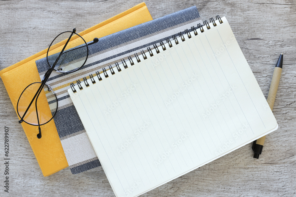 Modern office desk with yellow notepads and glasses and other supplies ...