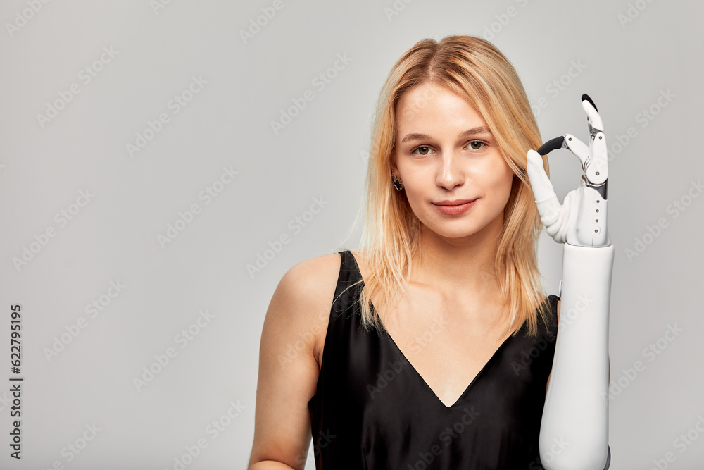 Studio portrait of beautiful young blonde girl with disability wearing ...