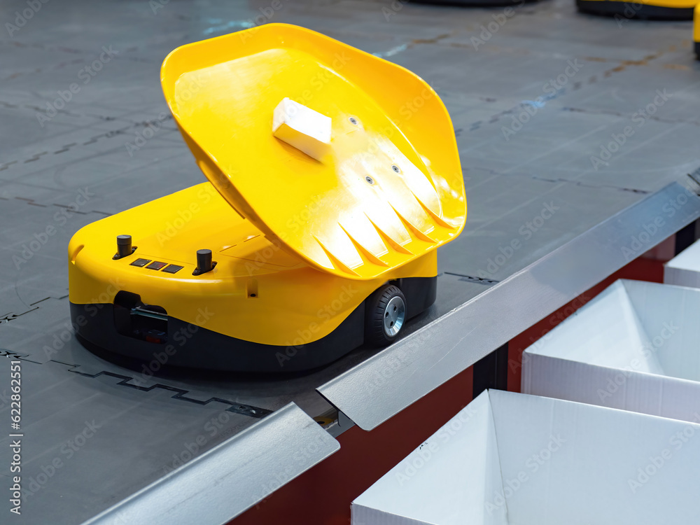 Sorting warehouse robot. Automated guided vehicles. Robot delivers box ... Sorting warehouse robot. Automated guided vehicles. Robot delivers box ...