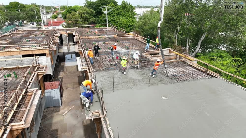 Drone view of workman pouring concrete with automatic pump tube on ...