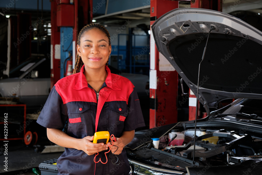 One Black female professional automotive mechanical worker checks an EV ...