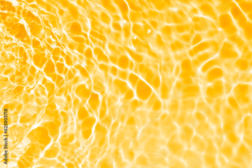 Yellow water with ripples on the surface. Defocus blurred transparent ...