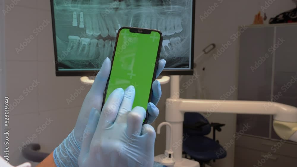 Closeup dentist hands sterile glove hold green screen cellphone at ...