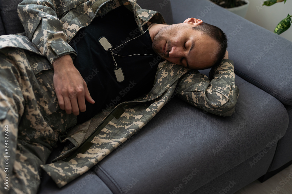 Tired military man sleeping on couch at home Stock Photo | Adobe Stock