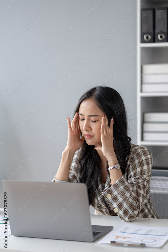 Beautiful asian woman suffering from stress due to working long hours ...