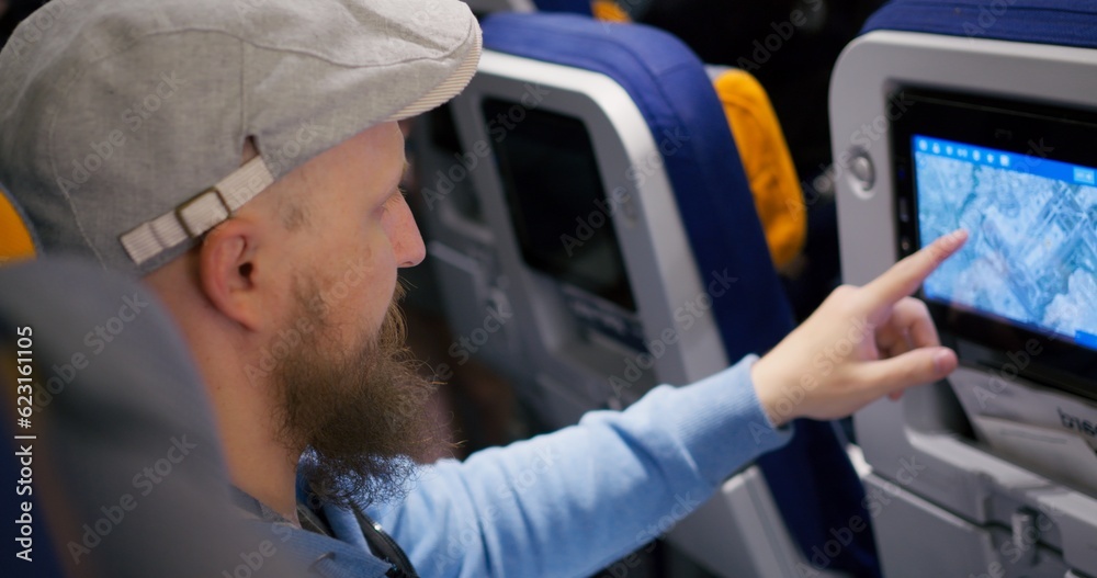 Man uses Airplane seat screen, in-flight travel entertainment system ...
