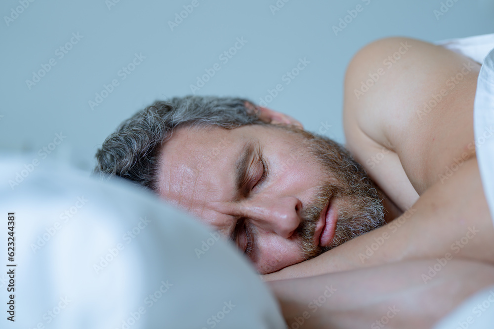 Man sleeping in bed. Top view of handsome man sleeping in bed. Morning ...