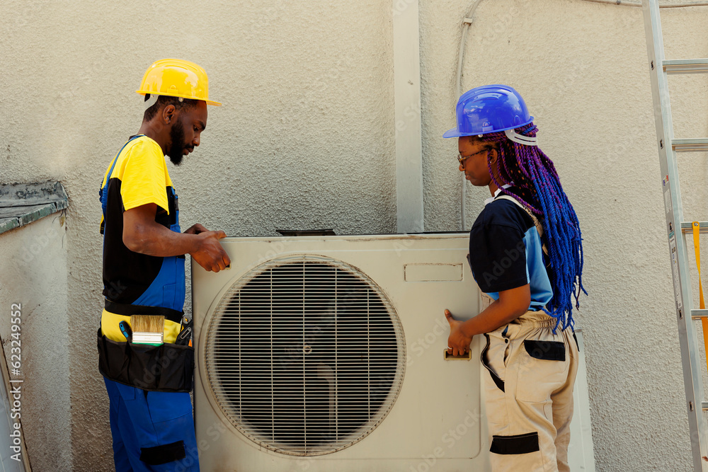 African american engineering coworkers opening up rusty out of service ...