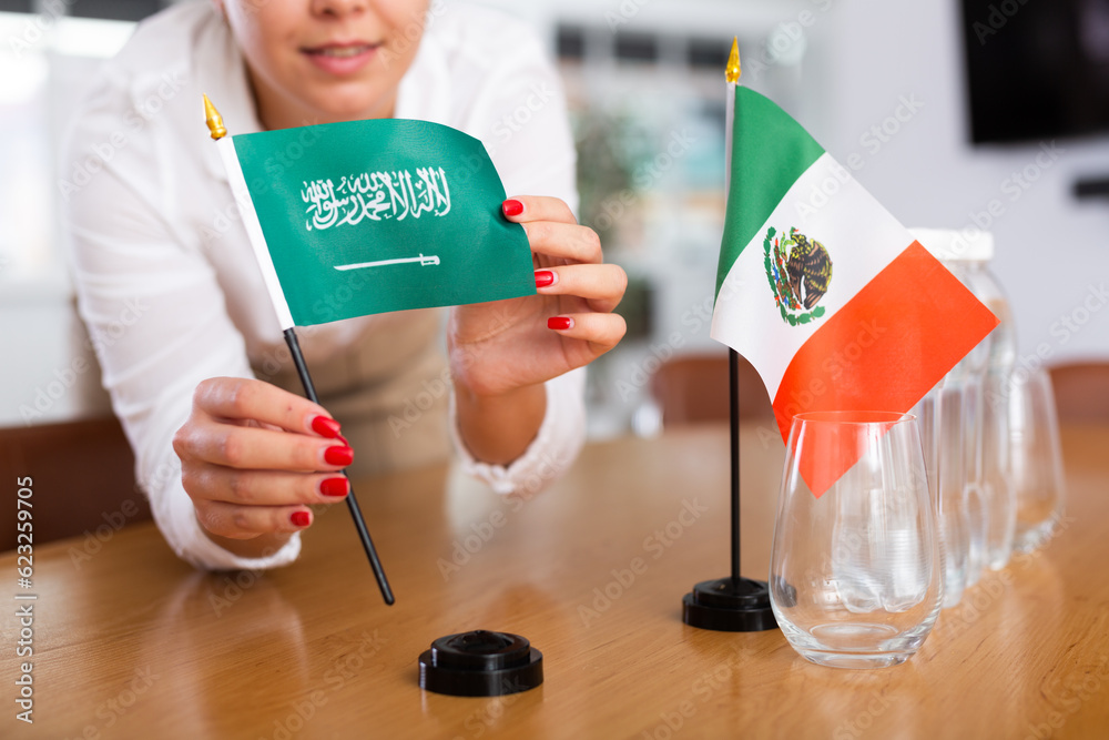 Secretary shows the flags of Mexico and Saudi Arabia on the table ...