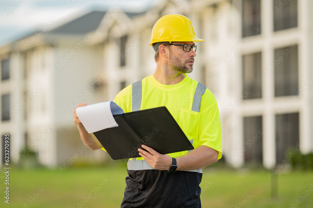 Engineer with clipboard, building inspection. Builder at construction ...