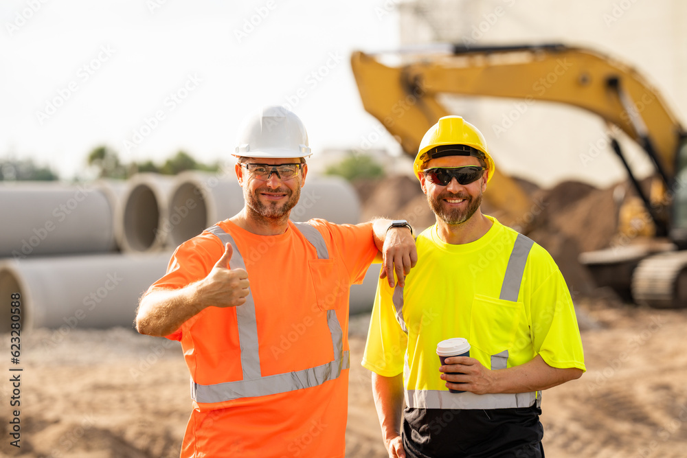 Construction site workers in a helmet work hard. Two workers in a hard ...