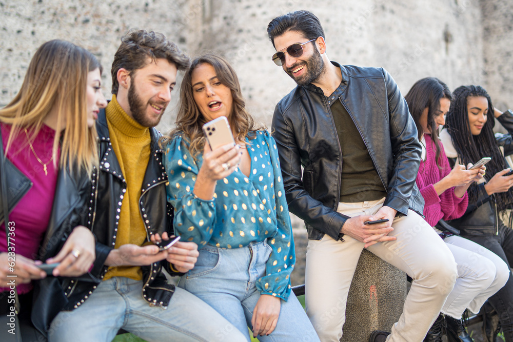 Friends Laughing and Sharing Social Media Content Outdoors - A group of ...