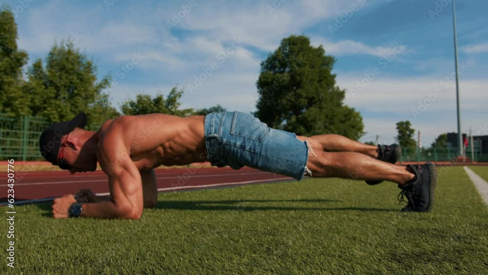 Young muscular man training on edge of football field and doing ...
