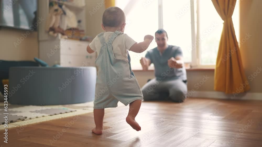 baby first steps. baby goes to her father at window learns to walk to ...