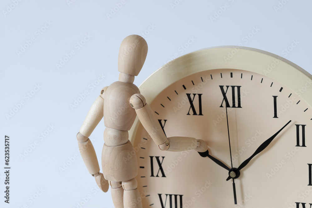 Time pressure. The wooden man turns the clock back Stock Photo | Adobe ...