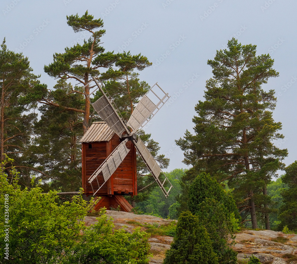 Old, red, wooden windmill in the Åland Islands with forest all around ...