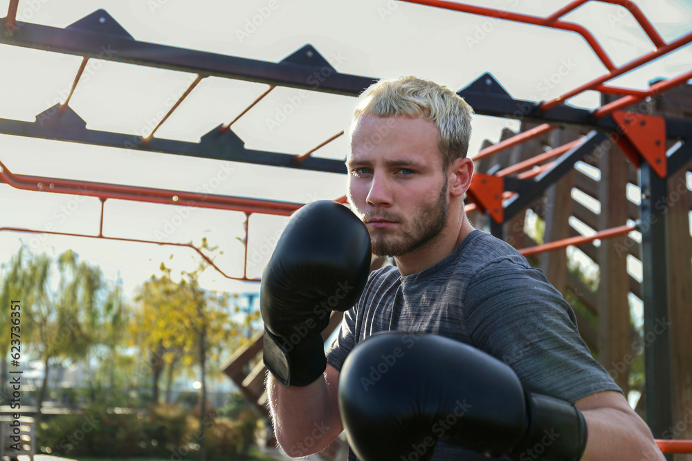 Boxer practicing his moves at the park. Young man training martial arts ...