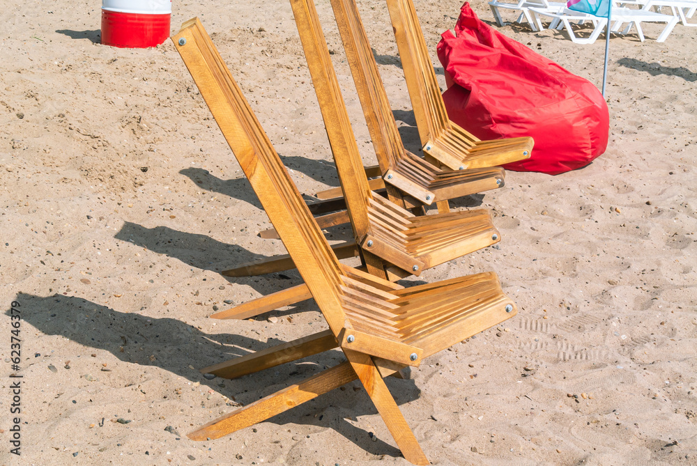Wooden folding chairs on the sandy beach. Relaxing and sunbathing on ...