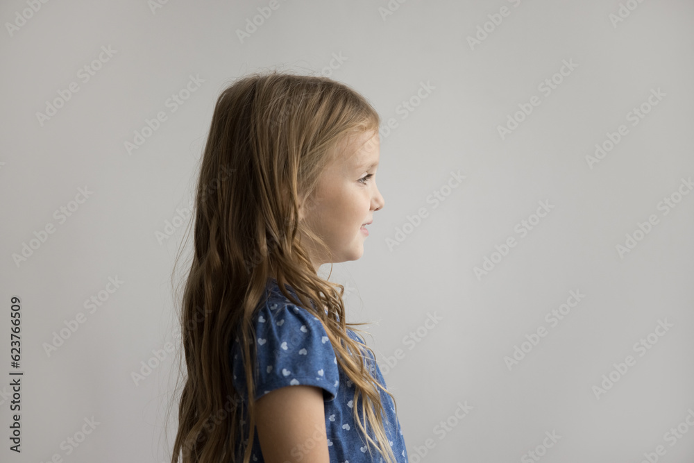 Positive beautiful little kid girl standing at white wall background ...