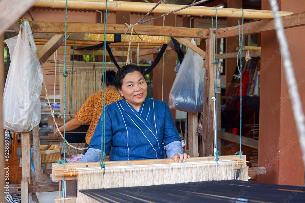 Asian female weavers weaving traditional patterns with hand weaving ...