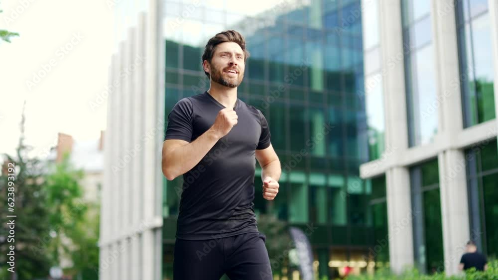 Handsome bearded male runner running on a modern urban background of ...