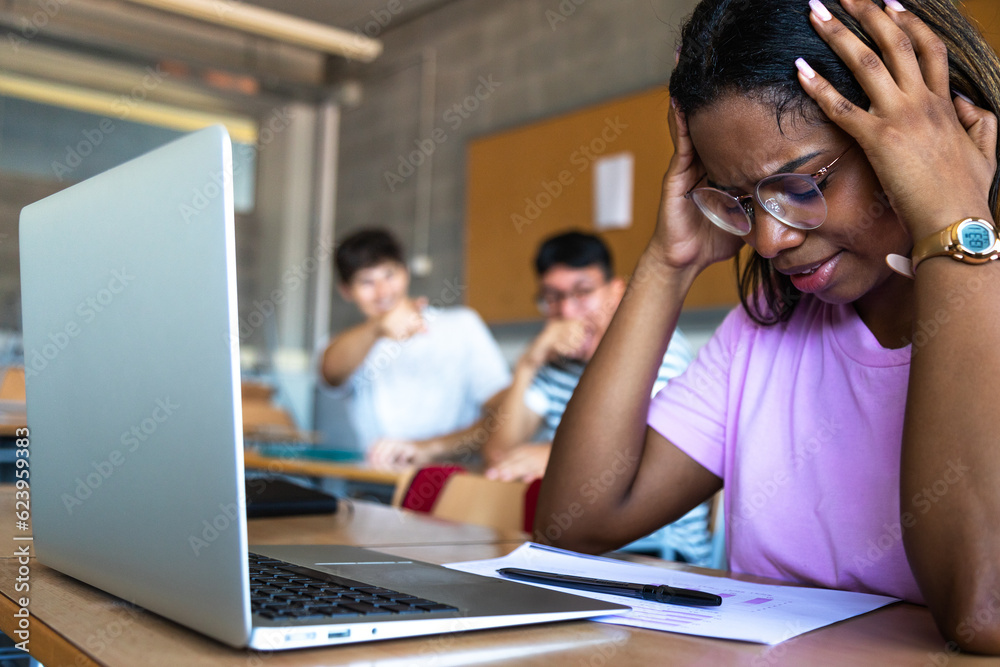 Sad female black teen high school student being bullied by classmates ...