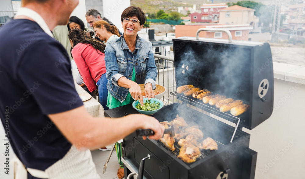 Happy friends cooking corncobs and chicken at barbecue rooftop dinner ...